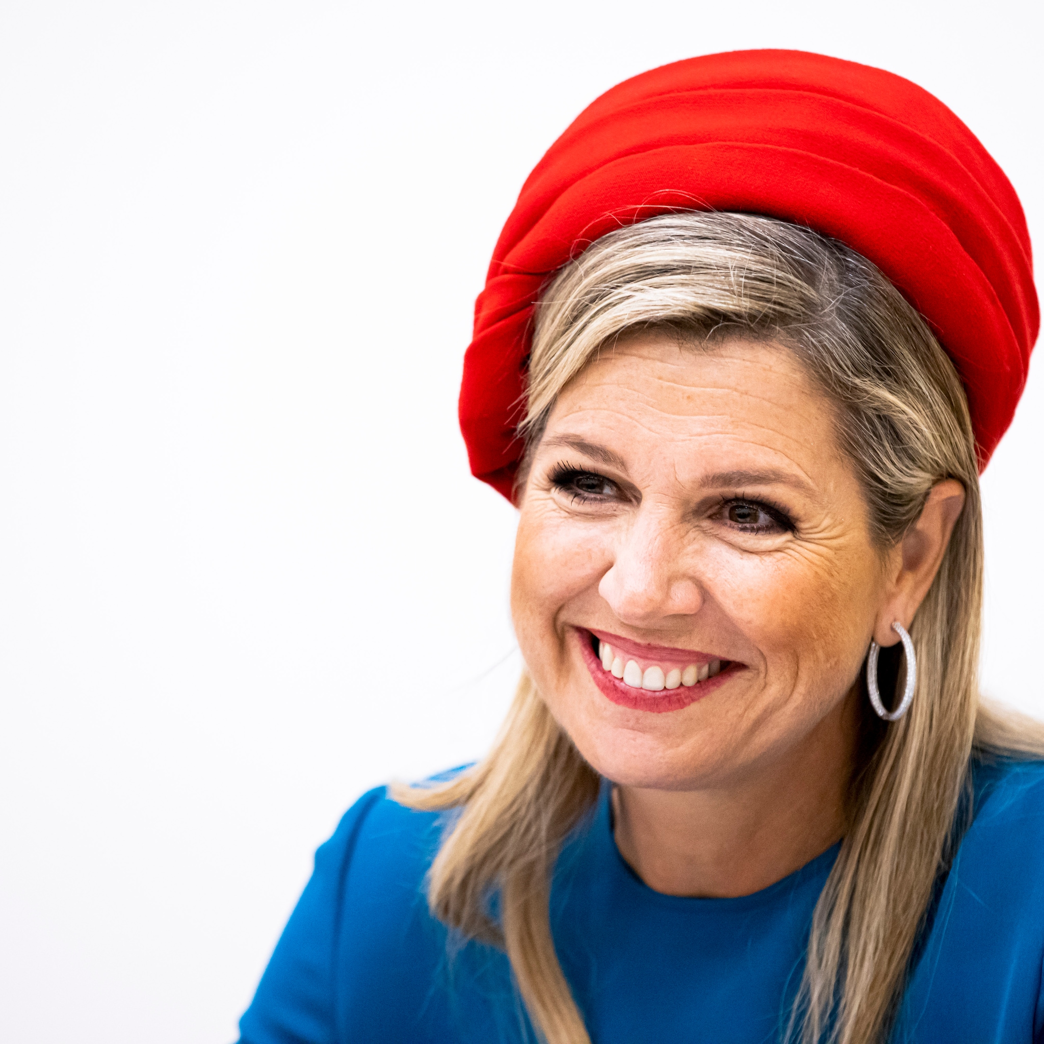 Máxima op Cyprus: een rode jurk en broche met een boodschap
